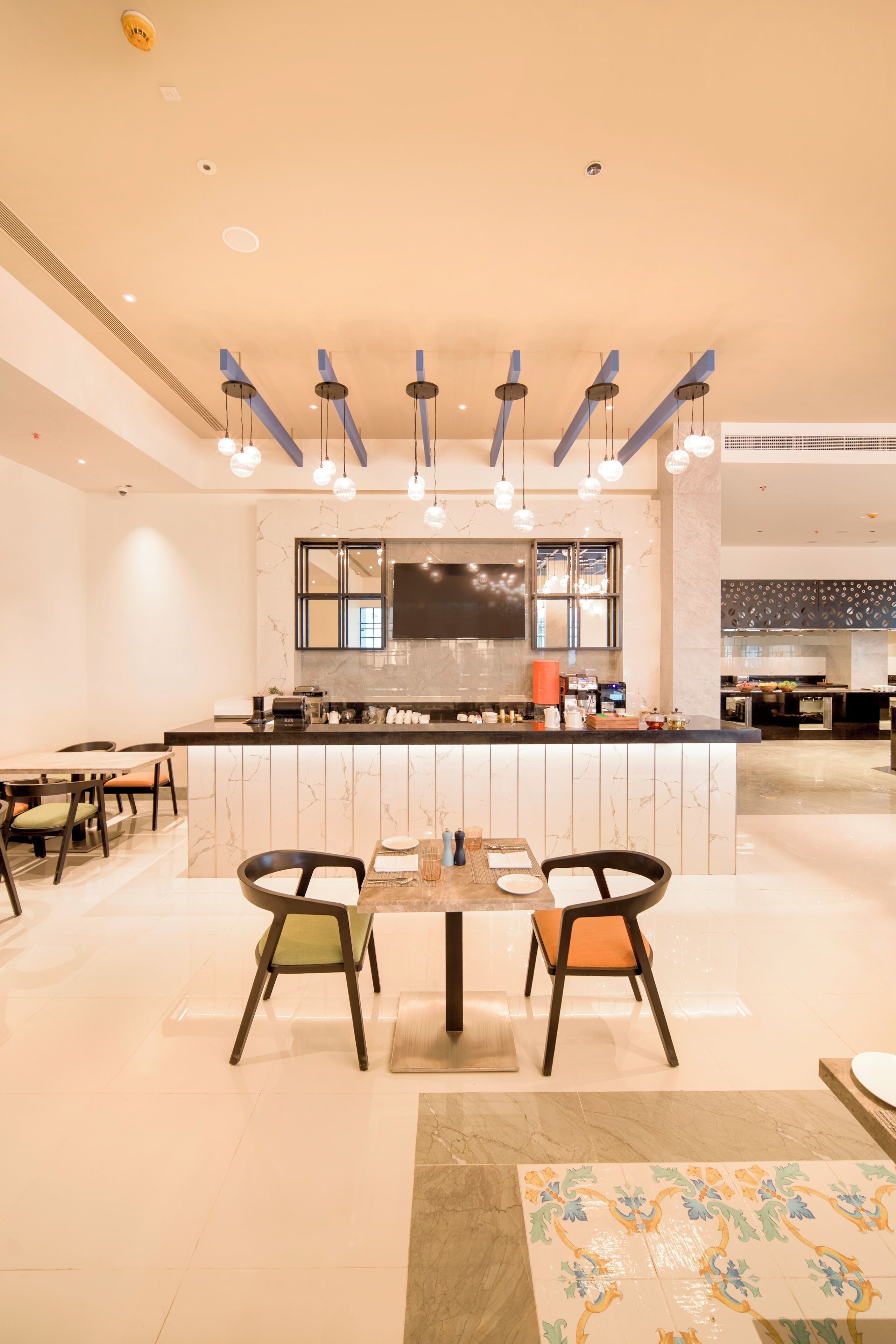 Uma cozinha moderna com ilha central, espaço para bar e área de jantar com cadeiras.