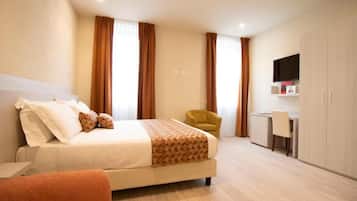 Quarto de hotel com cama, escrivaninha, cadeira e guarda-roupa.