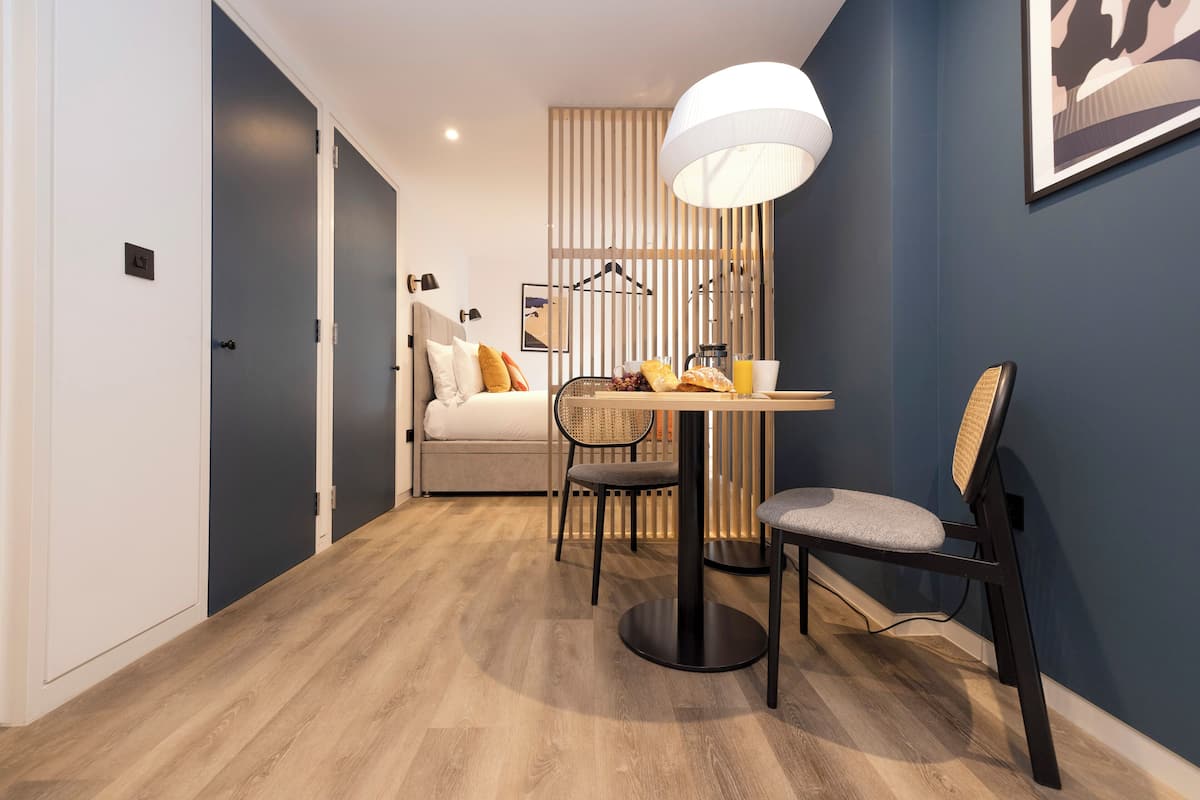 Quarto moderno com mesa de jantar, cadeiras, um sofá e uma luminária.