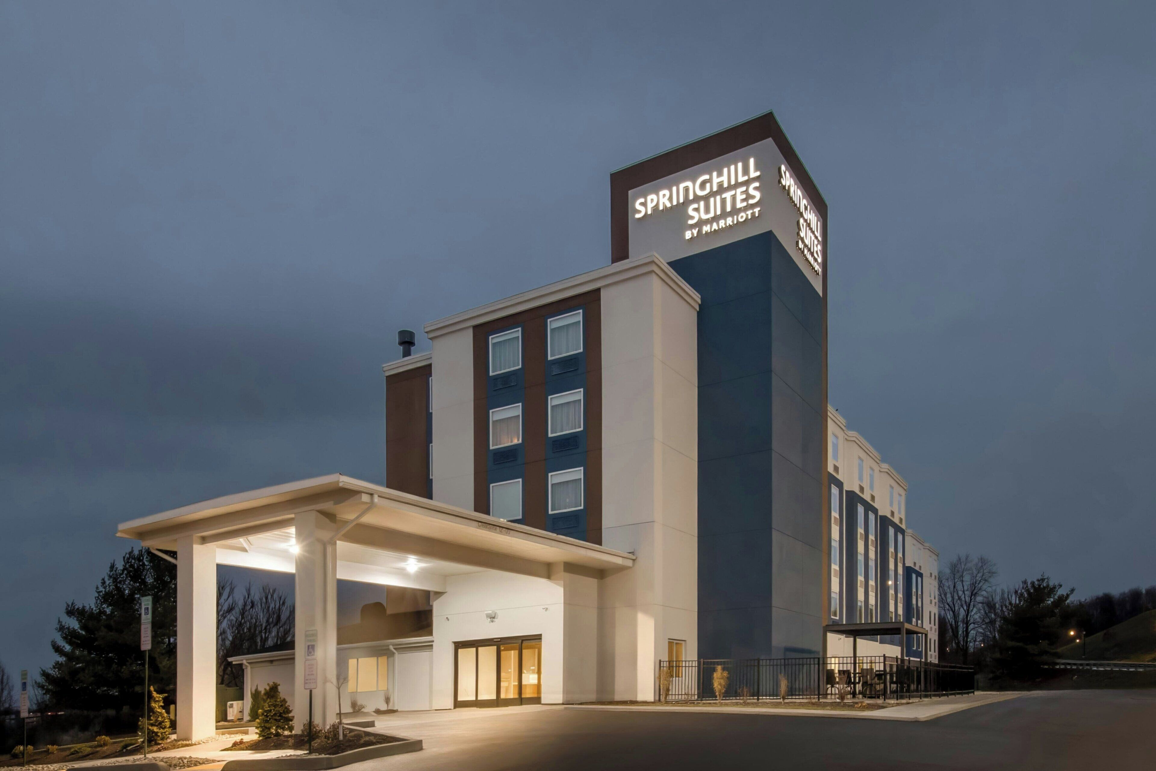 Um hotel com uma placa grande indicando "Springhill Suites by Marriott" e uma área de entrada coberta.