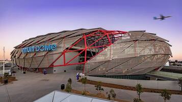Um estádio moderno com uma estrutura em forma de concha e o nome 'INTUIT DCME' em sua fachada.
