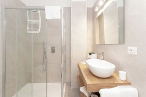 Quarto Deluxe, vista para o pátio | Casa de banho | Um polibã, um secador de cabelo, toalhas fornecidas, sabão 
