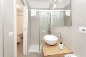Quarto Triplo Comfort, vista para o pátio | Casa de banho | Um polibã, um secador de cabelo, toalhas fornecidas, sabão 