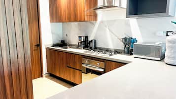 Apartamento Deluxe | Cozinha privada | Um frigorífico, um micro-ondas, um forno, uma placa de cozinha
