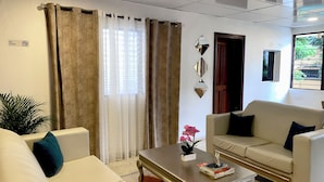 Uma sala de estar com sofá, mesa de centro e uma porta.