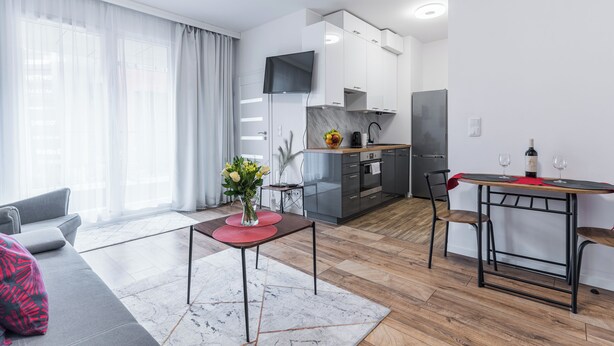 Apartamento moderno com sala de estar, cozinha e área de jantar.