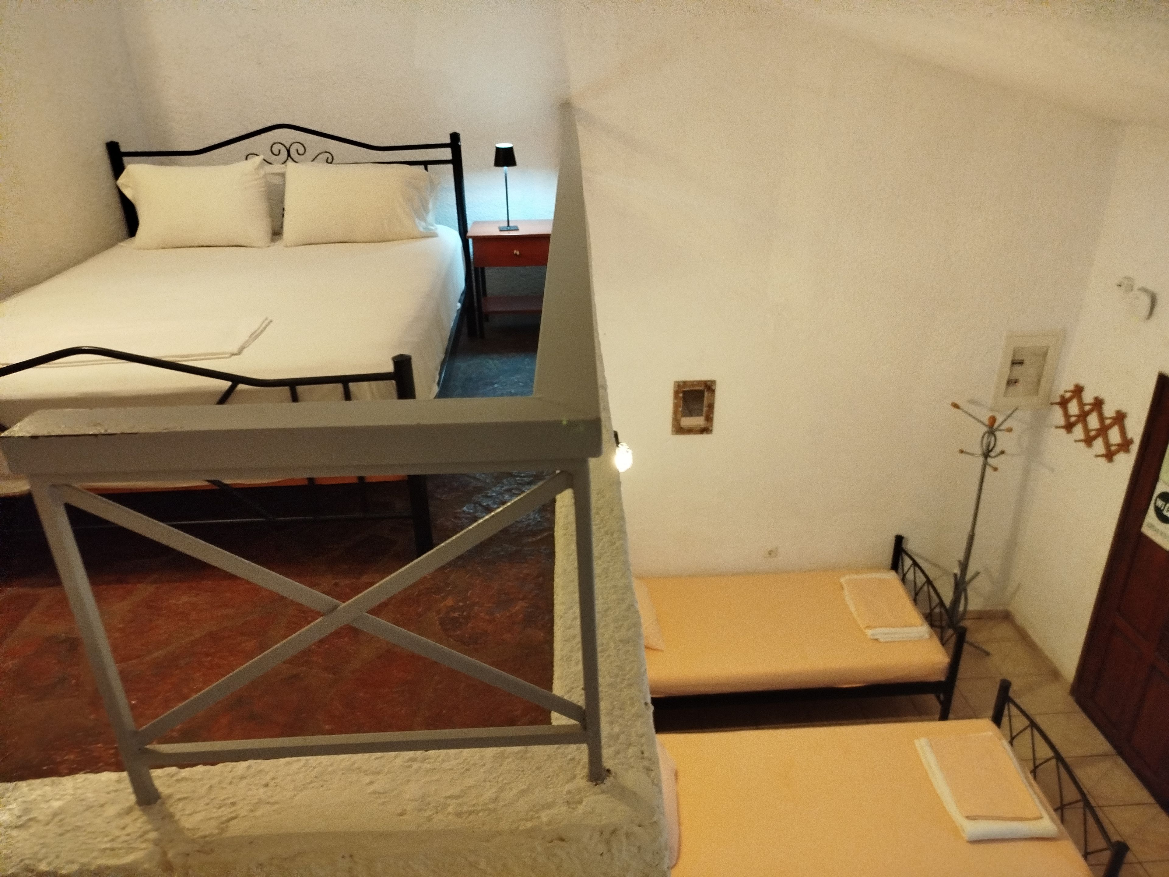 Quarto com cama, uma mesinha e uma cadeira.