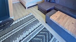 Quarto de sótão aconchegante com cama, sofá e uma pequena mesa.
