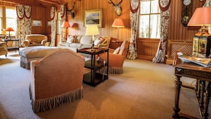 Um quarto acolhedor com lareira, um sofá, uma mesa de centro e um candelabro.