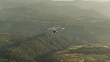 Um planador voando sobre uma paisagem montanhosa.