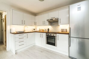 Apartamento | Cozinha privada | Uma chaleira elétrica, utensílios de cozinha