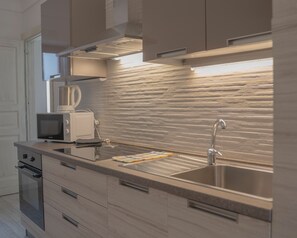 Apartamento Comfort | Cozinha privada | Um frigorífico, uma placa de cozinha, uma máquina de café expresso 