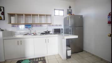 Um frigorífico/congelador grande, um micro-ondas, um forno