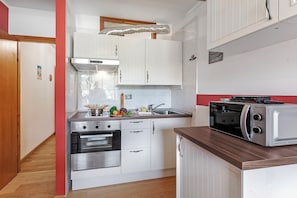 Um frigorífico, um micro-ondas, um forno, uma placa de cozinha