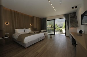 Quarto moderno com cama grande, escrivaninha e vista para o exterior.