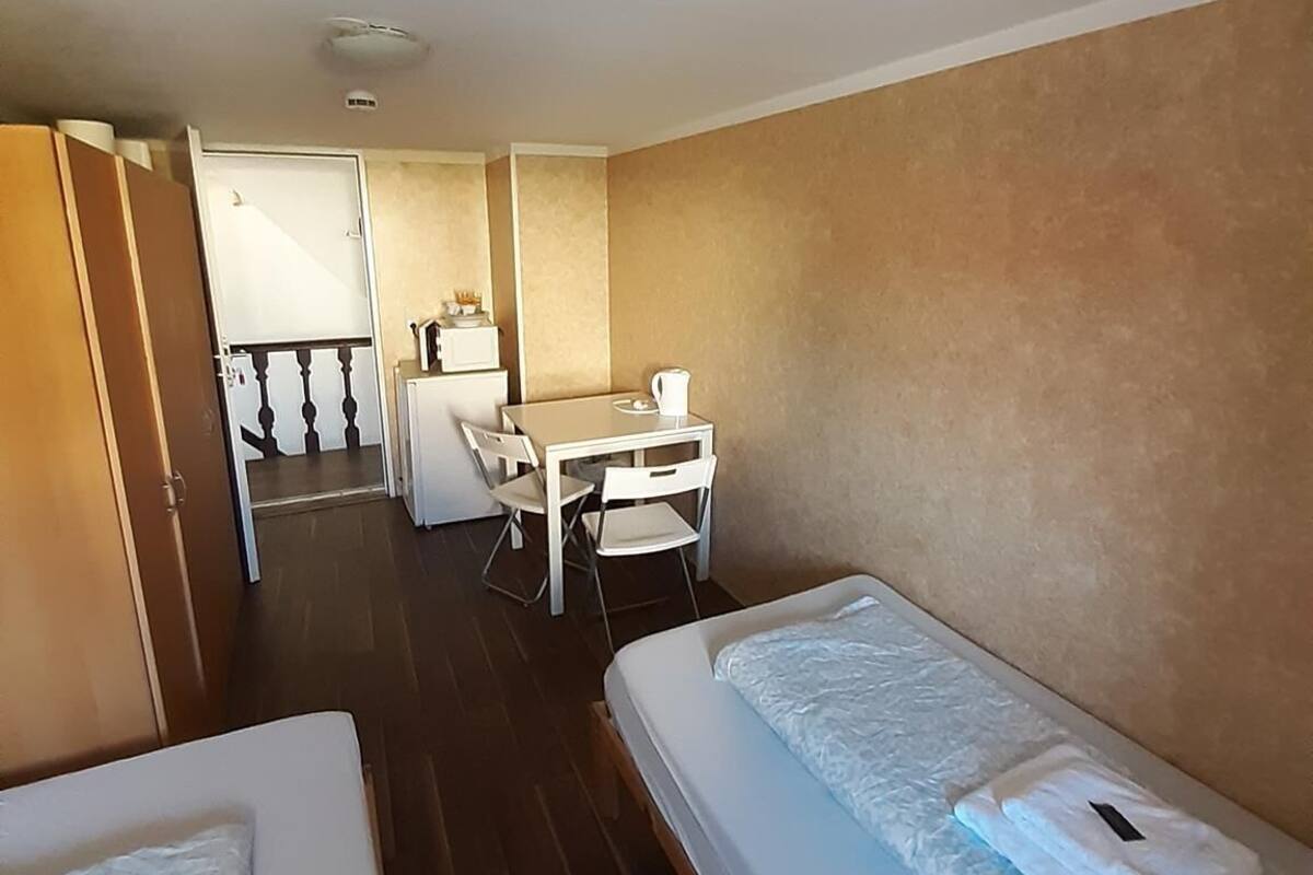 Quarto de hotel com cama, escrivaninha e cadeira.