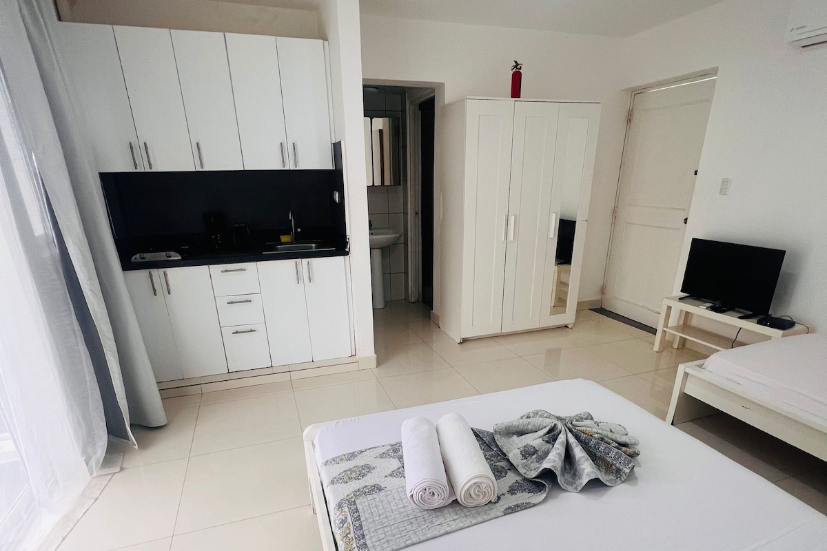 Quarto de hotel com cama, televisão, guarda-roupa e casa de banho.
