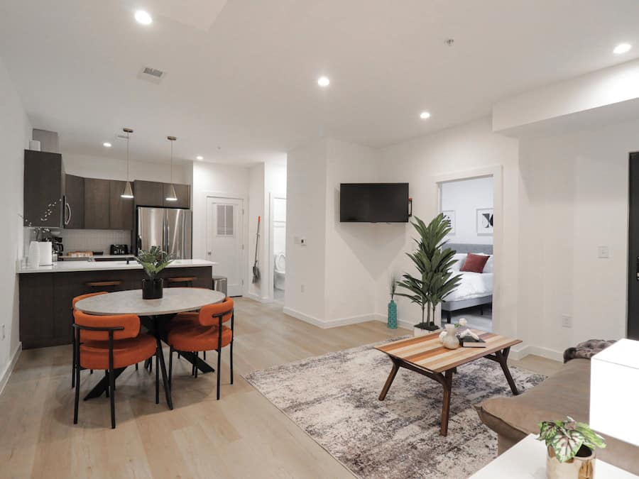 Um apartamento moderno com cozinha, sala de jantar, sala de estar e um quarto.