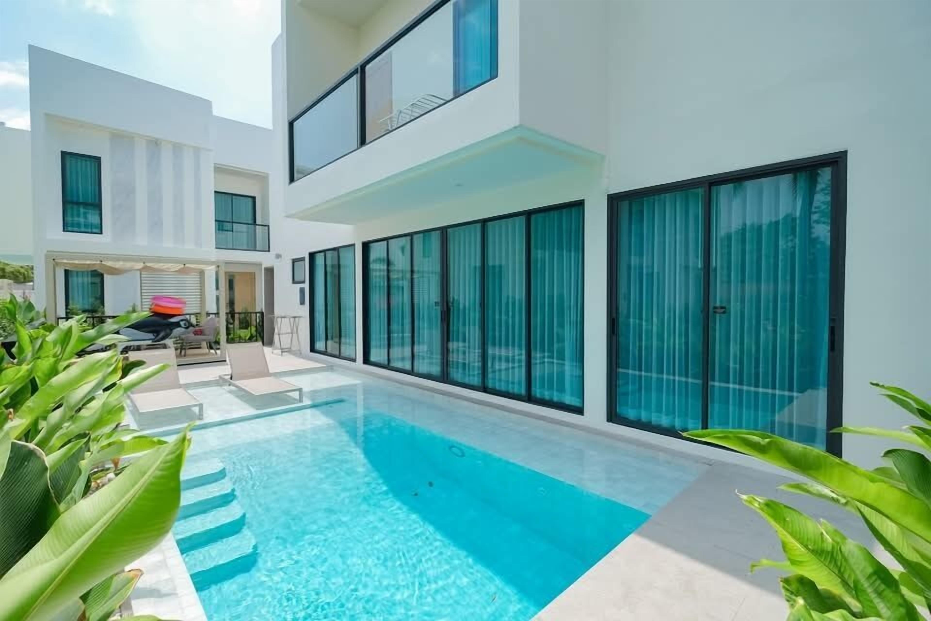 Uma casa moderna com piscina, janelas amplas e varanda.