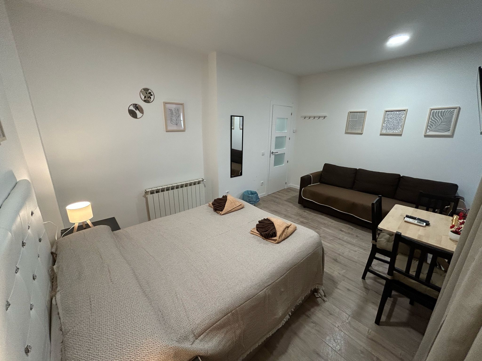 Quarto com cama, mesa de cabeceira, penteadeira, janela e porta.