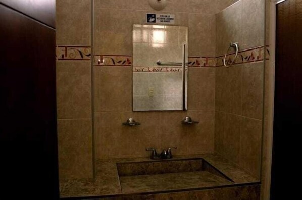 Casa de banho com espelho, lavatório e um sinal acima do espelho.