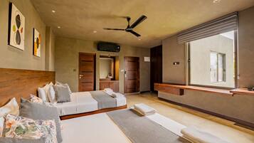 Quarto moderno com cama grande, sofá, televisão e janela.