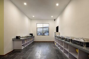 Quarto de hotel com uma grande janela, minibar e televisão de tela plana.