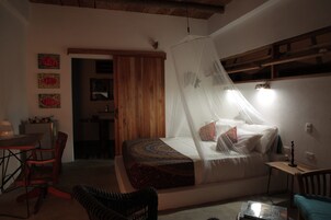 Quarto com cama, escrivaninha, cadeira e mesa de jantar.