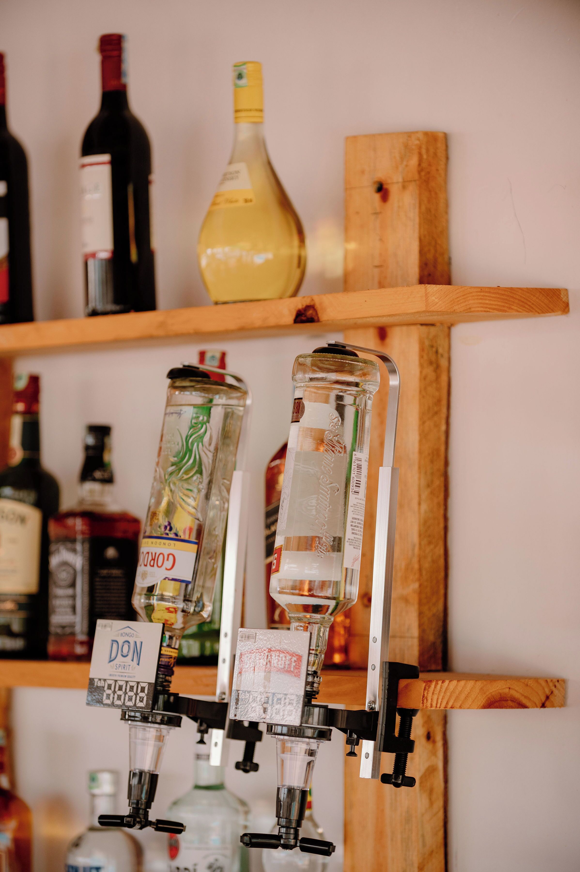 Uma área de bar com diversas garrafas de bebidas e um sistema de chopp.