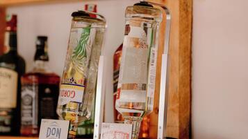 Uma área de bar com diversas garrafas de bebidas e um sistema de chopp.