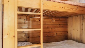 Uma cama beliche de madeira com colchão e cabeceira de madeira.