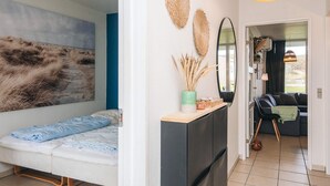 Quarto moderno com cama, espelho fixado na parede e objeto decorativo.