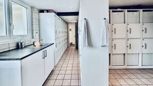 Cozinha moderna com armários brancos, piso azulejado e uma janela.