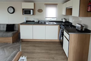 Um frigorífico, um micro-ondas, um forno, uma placa de cozinha