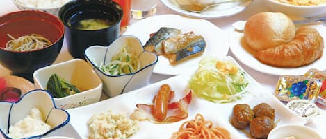 Uma mesa com diversos pratos, incluindo arroz, sopa, almôndegas e legumes.