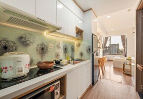 Cozinha moderna com armários brancos, forno embutido e fogão.