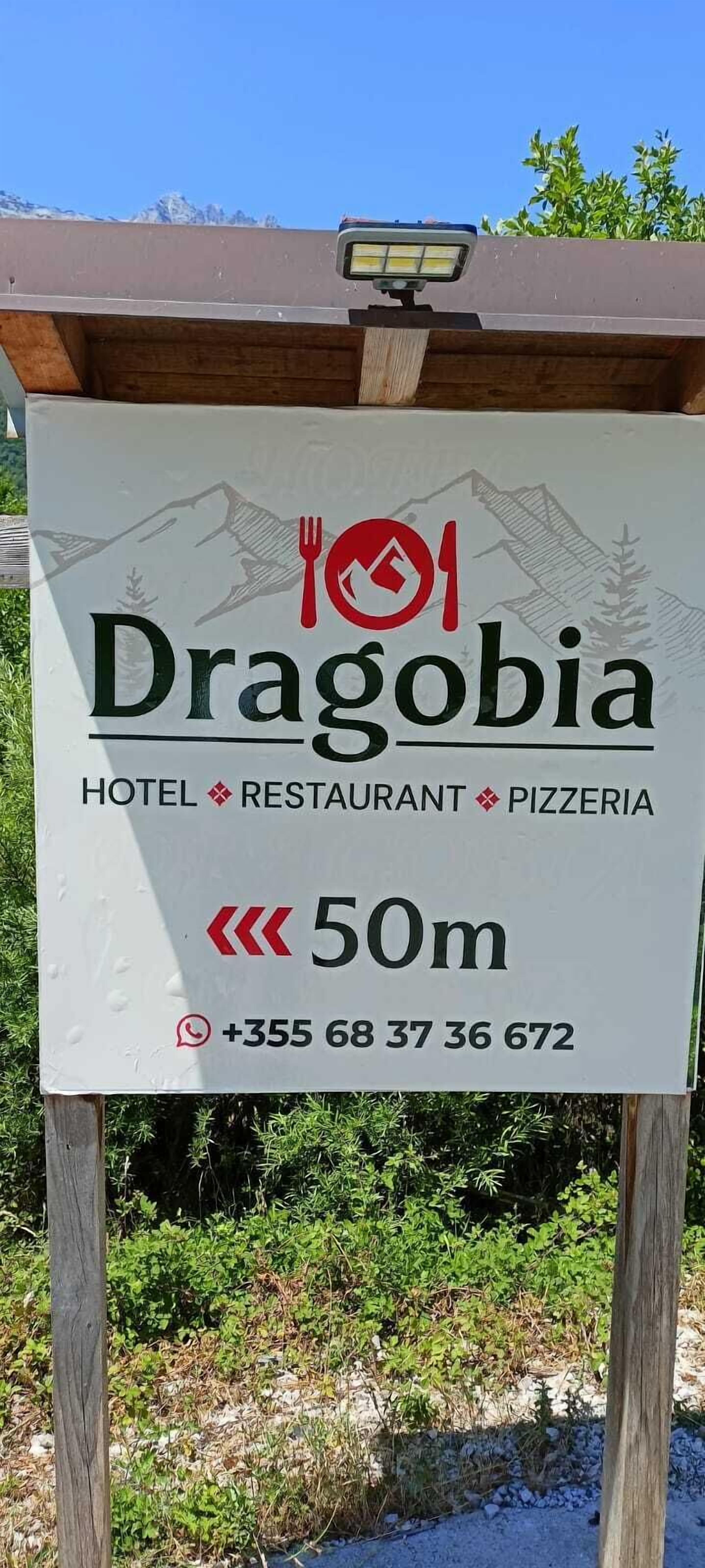Placa de Dragobia, um hotel, restaurante e pizzaria, a 50 metros, com número de contato.