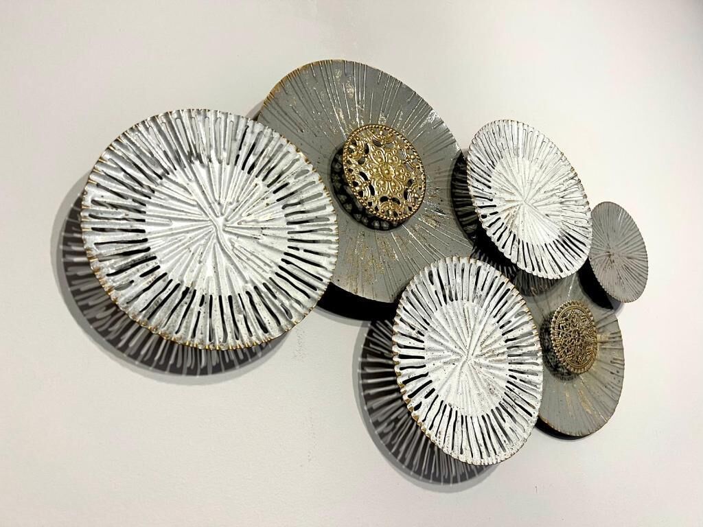 Conjunto de peças de arte em metal para parede, com padrões complexos e um elemento decorativo central.