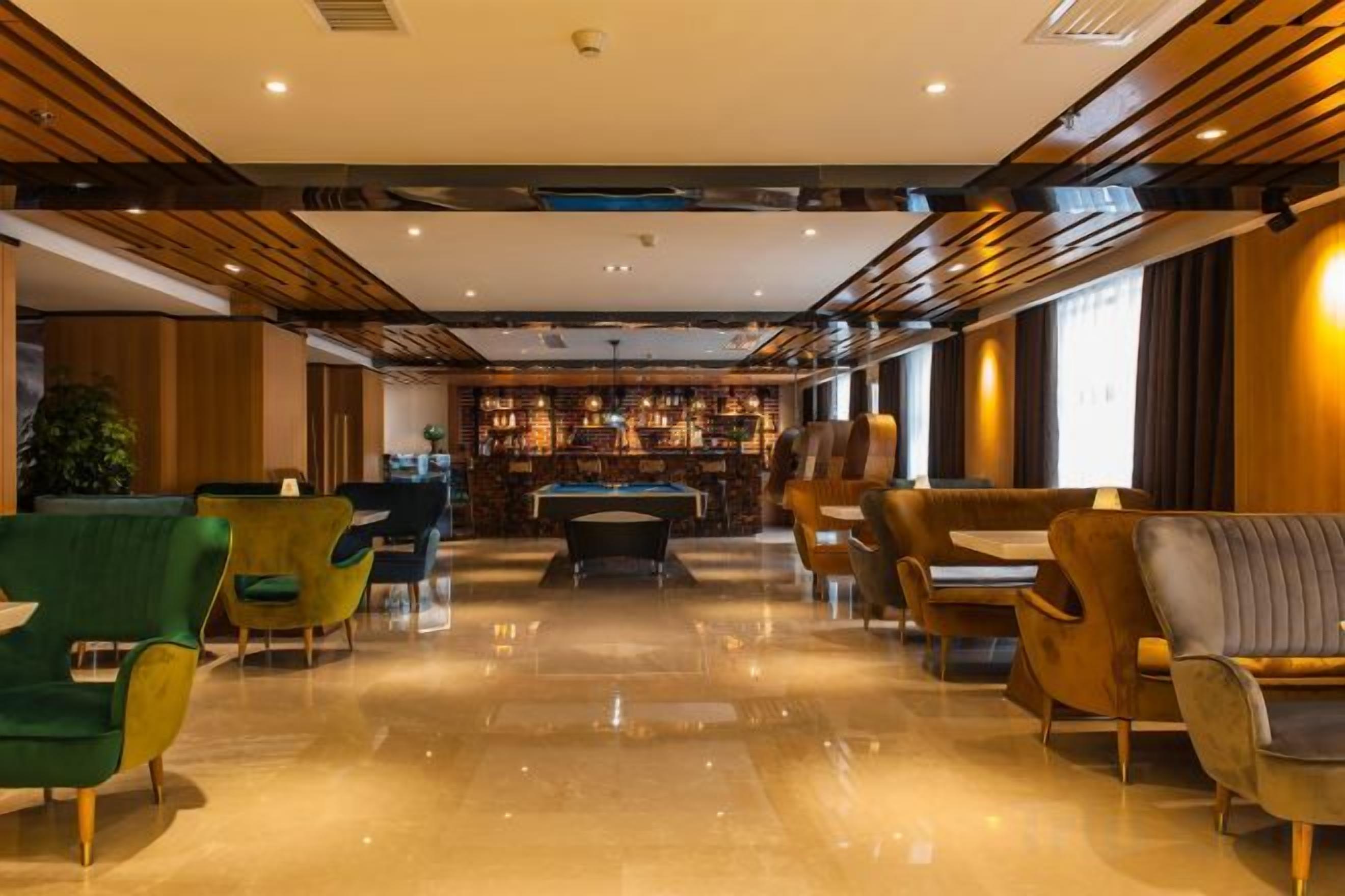 Um hall amplo com área de bar, opções de assento e piso impecável.