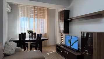 Apartamento Deluxe, 2 quartos, varanda, vista para o pátio | Sala de estar | Smart TV de 50 polegadas com canais por cabo, leitor de DVD