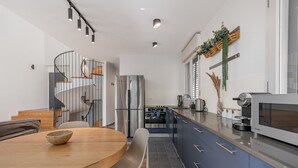 Uma cozinha moderna com uma ilha central, eletrodomésticos de aço inoxidável e forno embutido.