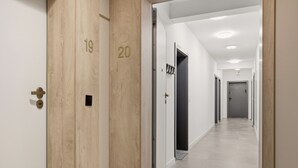 Corredor com portas numeradas 19 e 20, que dão acesso a quartos.