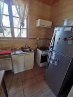 Um frigorífico, um forno, uma torradeira, utensílios de cozinha