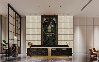 Uma receção com bancada de mármore, um logótipo e uma placa com o nome. Existem duas cadeiras e uma planta à esquerda.