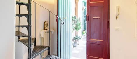 Uma escadaria com grades de metal ricamente decoradas que leva a uma porta.