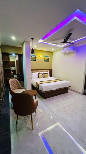 Quarto de hotel moderno com cama, escrivaninha, cadeira e ventilador de teto.