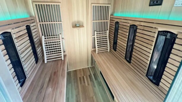 Uma sala de sauna com paredes e bancos de madeira.