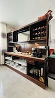 Cozinha equipada com máquina de café, espaço para vinhos e diversos utensílios.