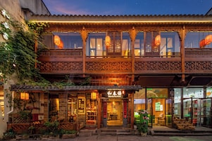 Um edifício tradicional de dois andares com restaurante no andar térreo e hotel no andar superior.