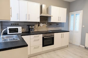 Um frigorífico, um micro-ondas, um forno, uma placa de cozinha